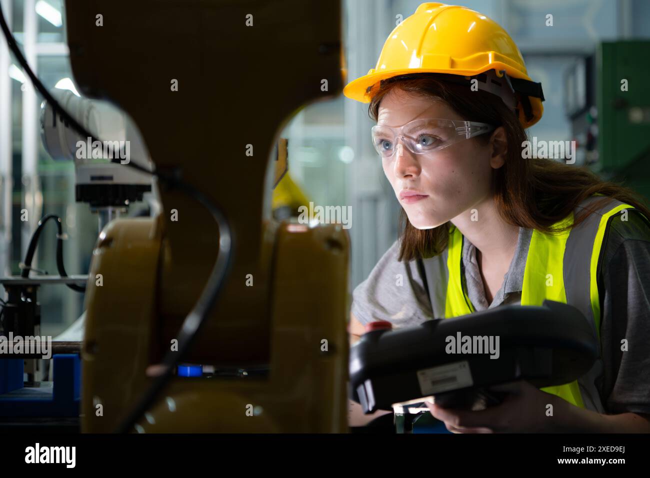 Female technician who maintains a small robot arm the operation of a ...