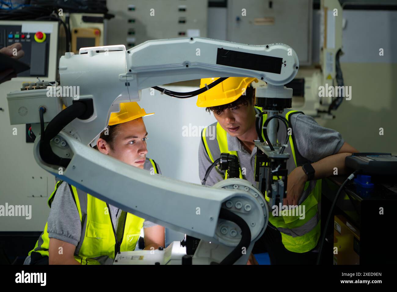 Technician who maintains a small robot arm the operation of a small ...