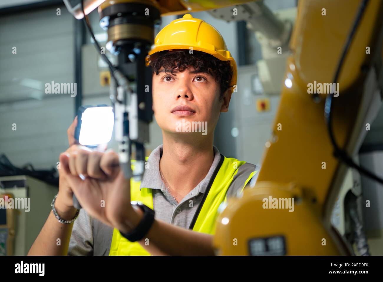 Technician who maintains a small robot arm the operation of a small ...