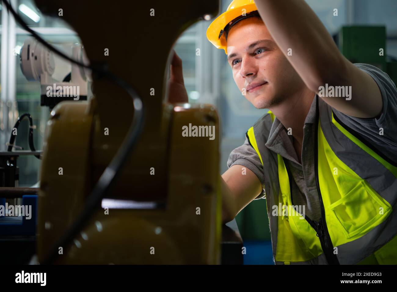 Technician who maintains a small robot arm the operation of a small ...