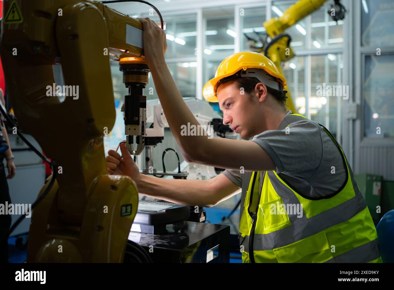 Technician who maintains a small robot arm the operation of a small ...