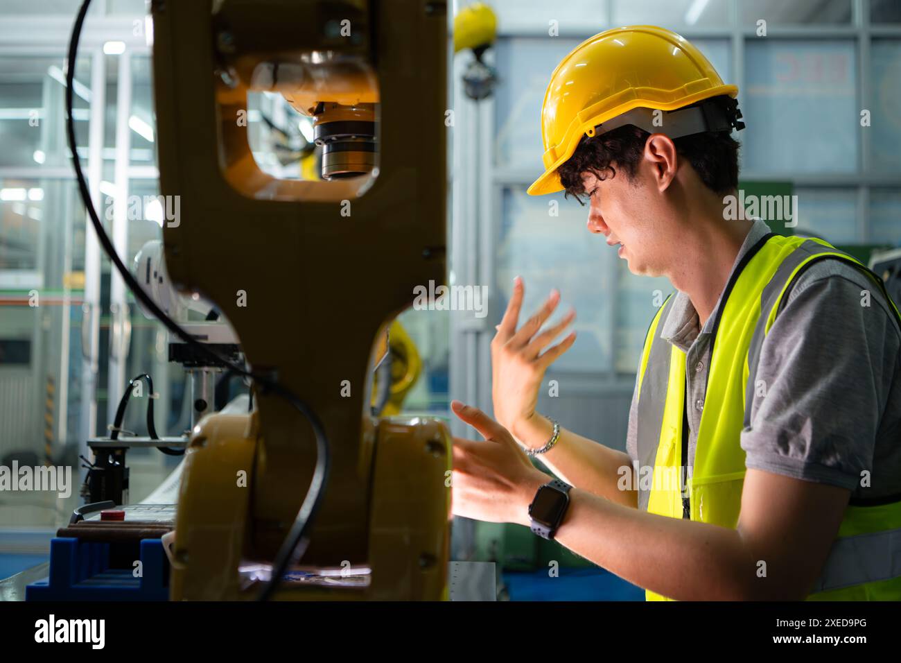 A technician suffers a hand accident while working with a robot arm in ...