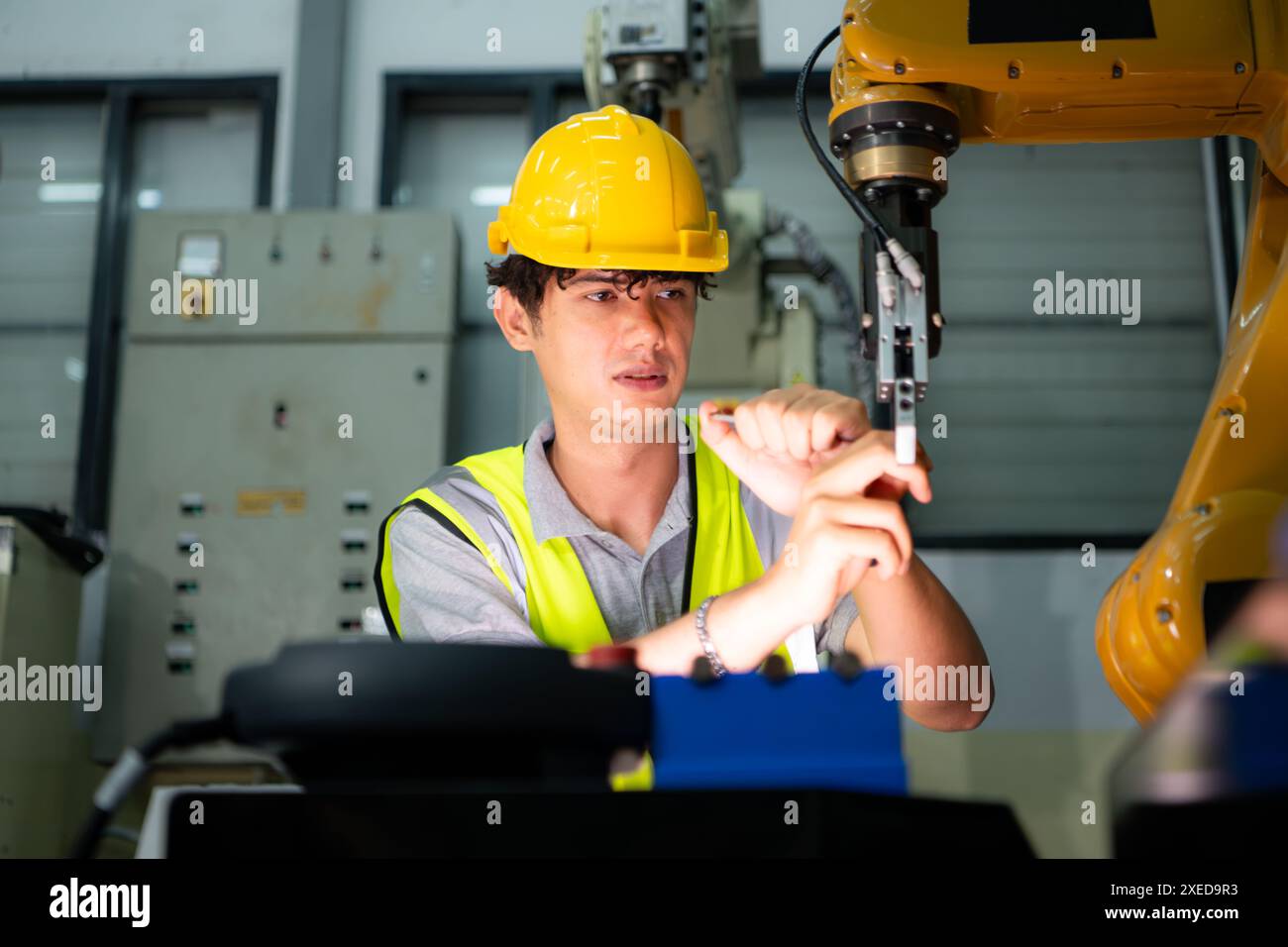 Technician who maintains a small robot arm the operation of a small ...