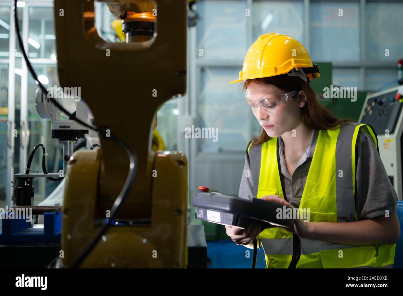 Female technician who maintains a small robot arm the operation of a ...