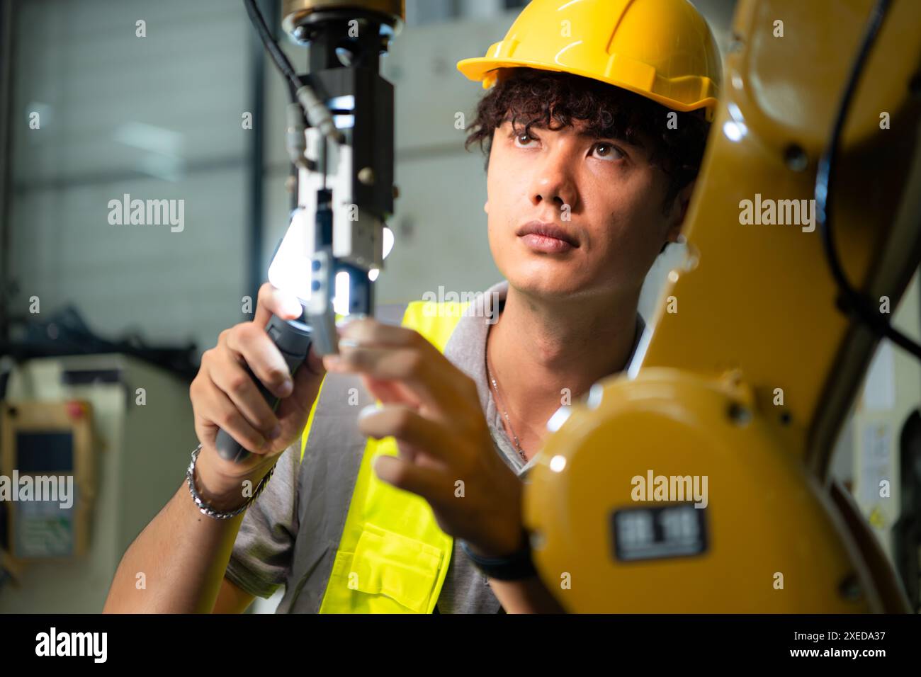 Technician who maintains a small robot arm the operation of a small ...