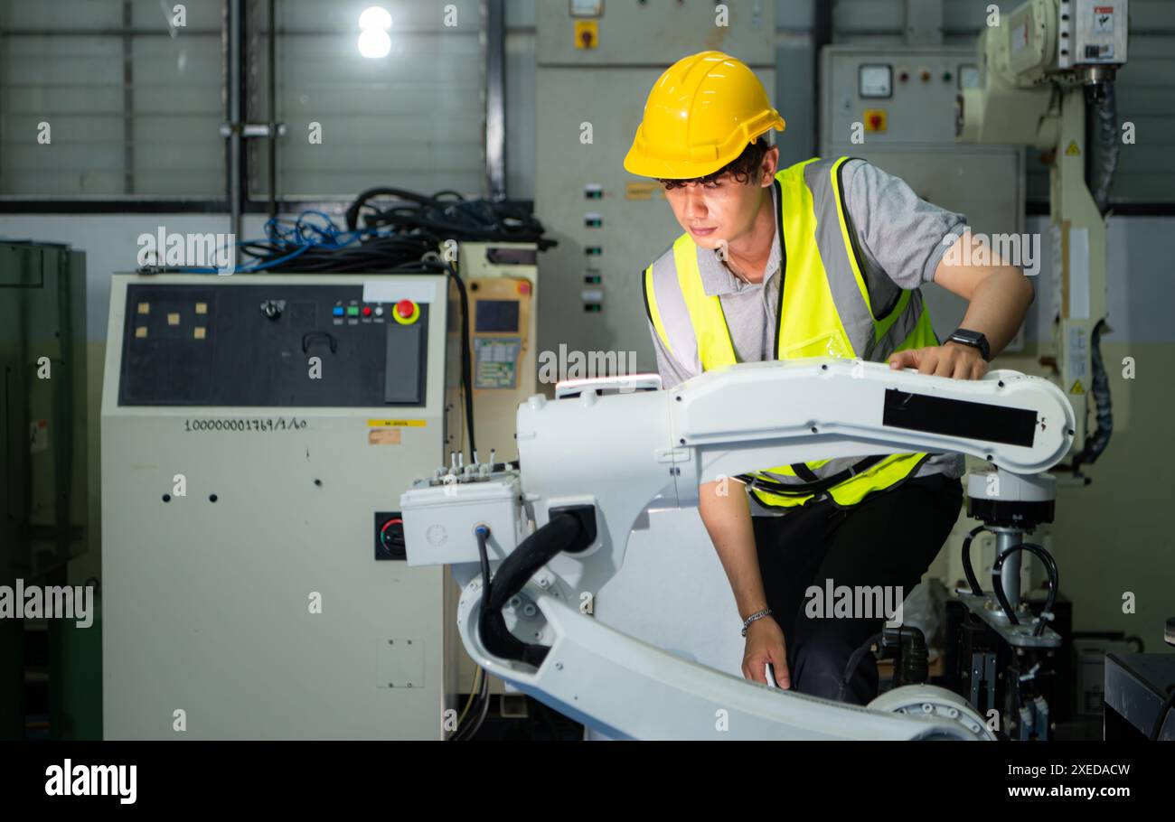 Technician who maintains a small robot arm the operation of a small ...
