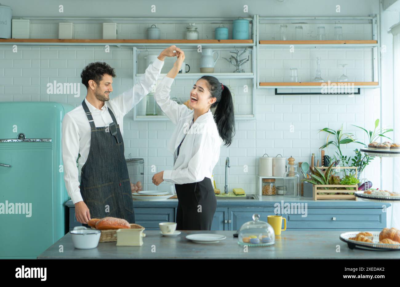 A husband wears an apron while cooking dinner with his wife. He was ...