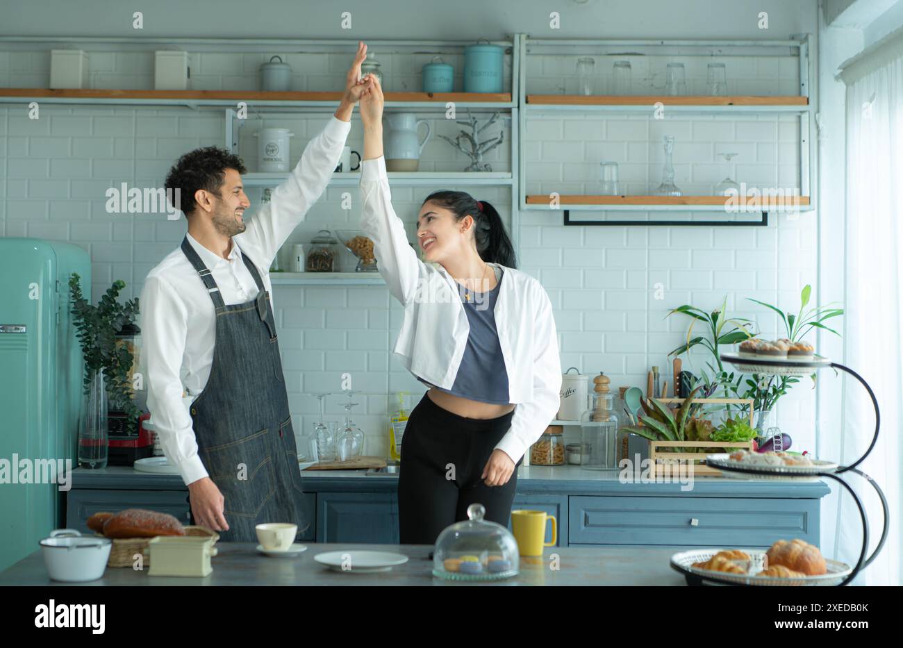 A husband wears an apron while cooking dinner with his wife. He was ...