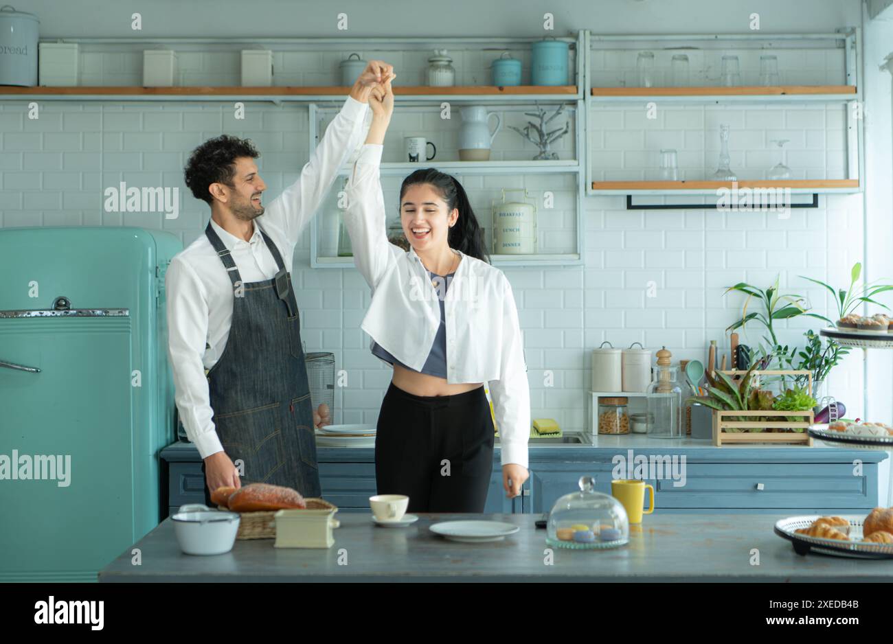 A husband wears an apron while cooking dinner with his wife. He was ...