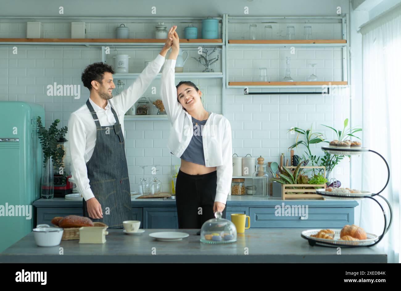 A husband wears an apron while cooking dinner with his wife. He was ...