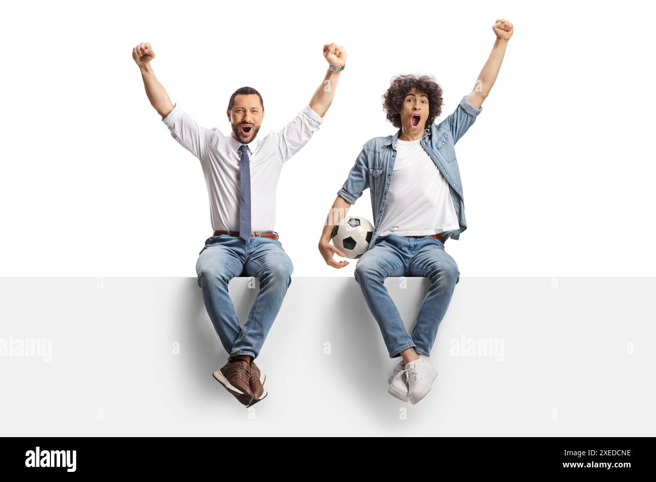 Happy young men cheering and holding a football seated on a blank panel ...
