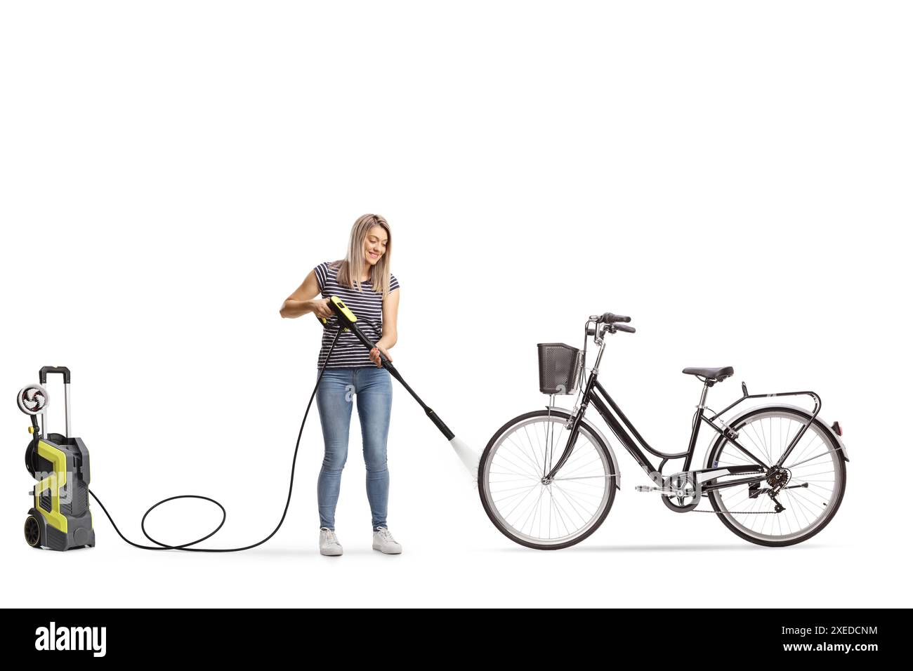 Young woman washing a bicycle with a high pressure washer machine ...
