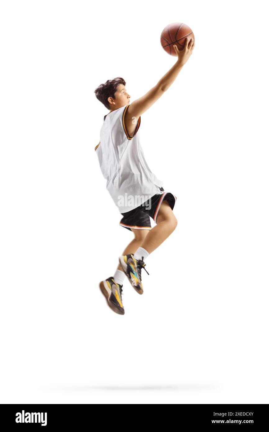 Teenage boy jumping with a basketball isolated on white background ...
