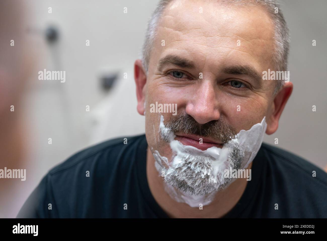 Middle aged handsome man shaving his beard in bathroom Stock Photo - Alamy