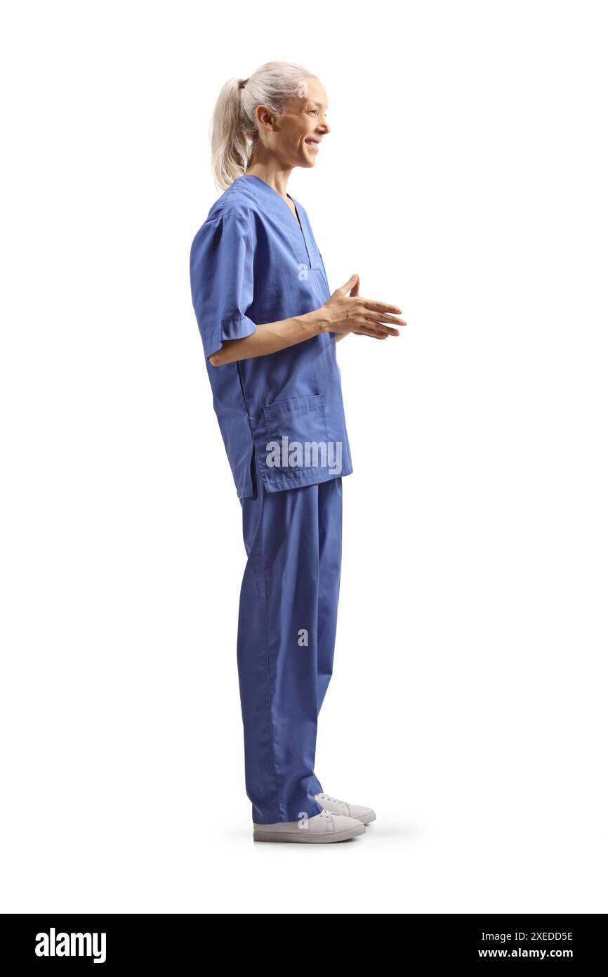 Full length profile shot of a smiling female health care worker in a ...