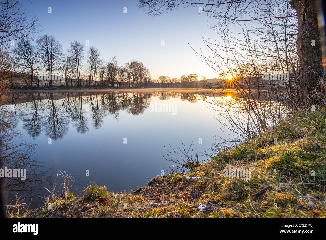 Sunset on a quiet lake in a valley surrounded by a forest Dutenhofener ...