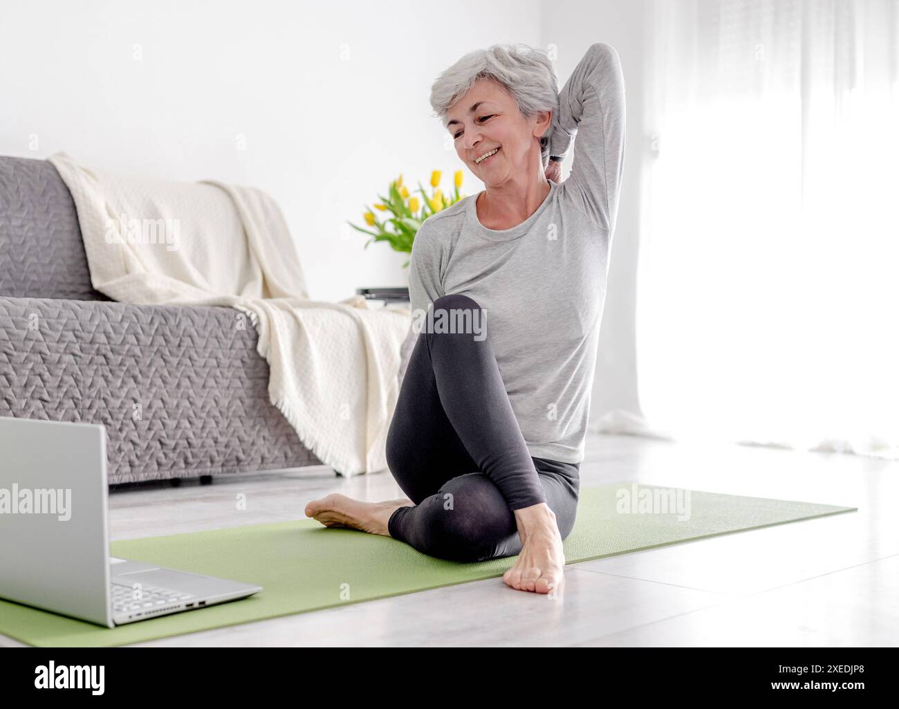Pleasant 70-Year-Old Woman Exercises With Trainer Through Laptop, Doing ...