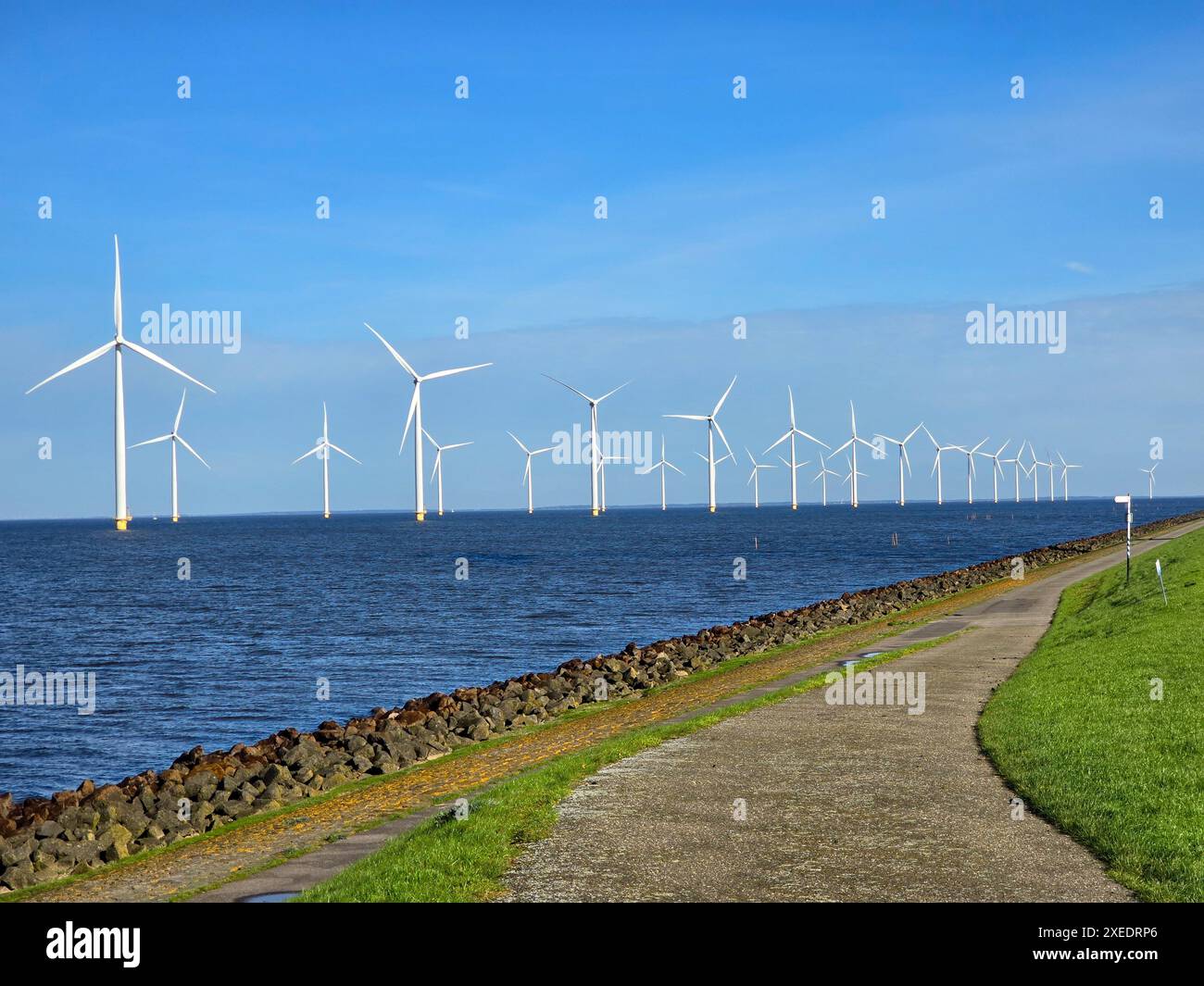 Windmill park in the ocean, view of windmill turbines on a Dutch dike ...