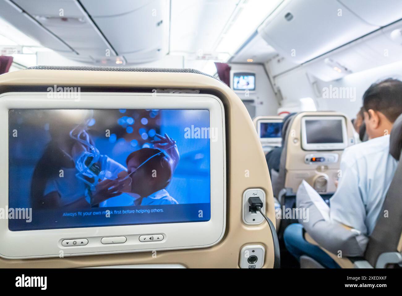Personal television, PTV in front of an airplane seat showing instructions on putting a mask to ...