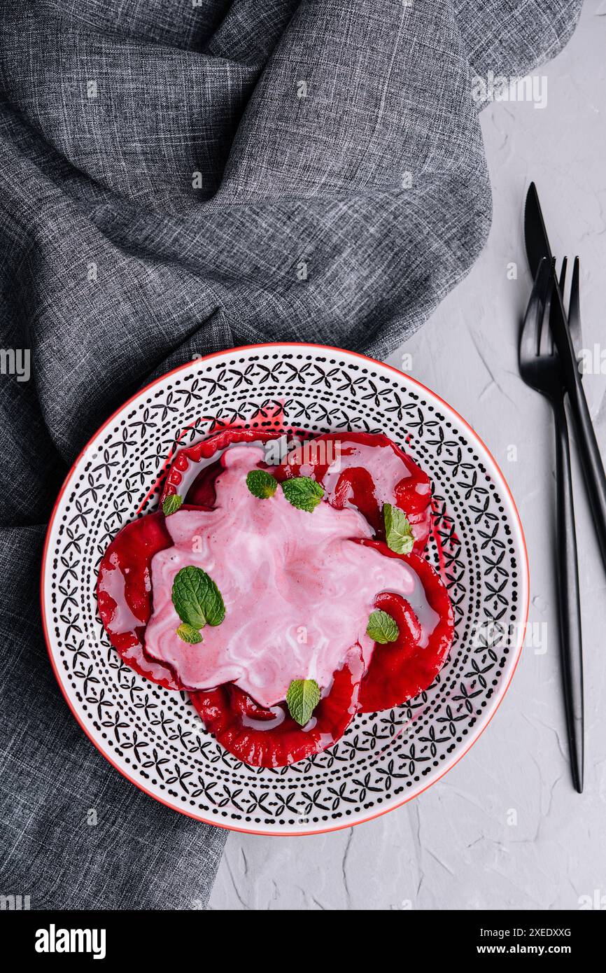 Vegan red ravioli with beetroot on a plate in cream sauce Stock Photo ...