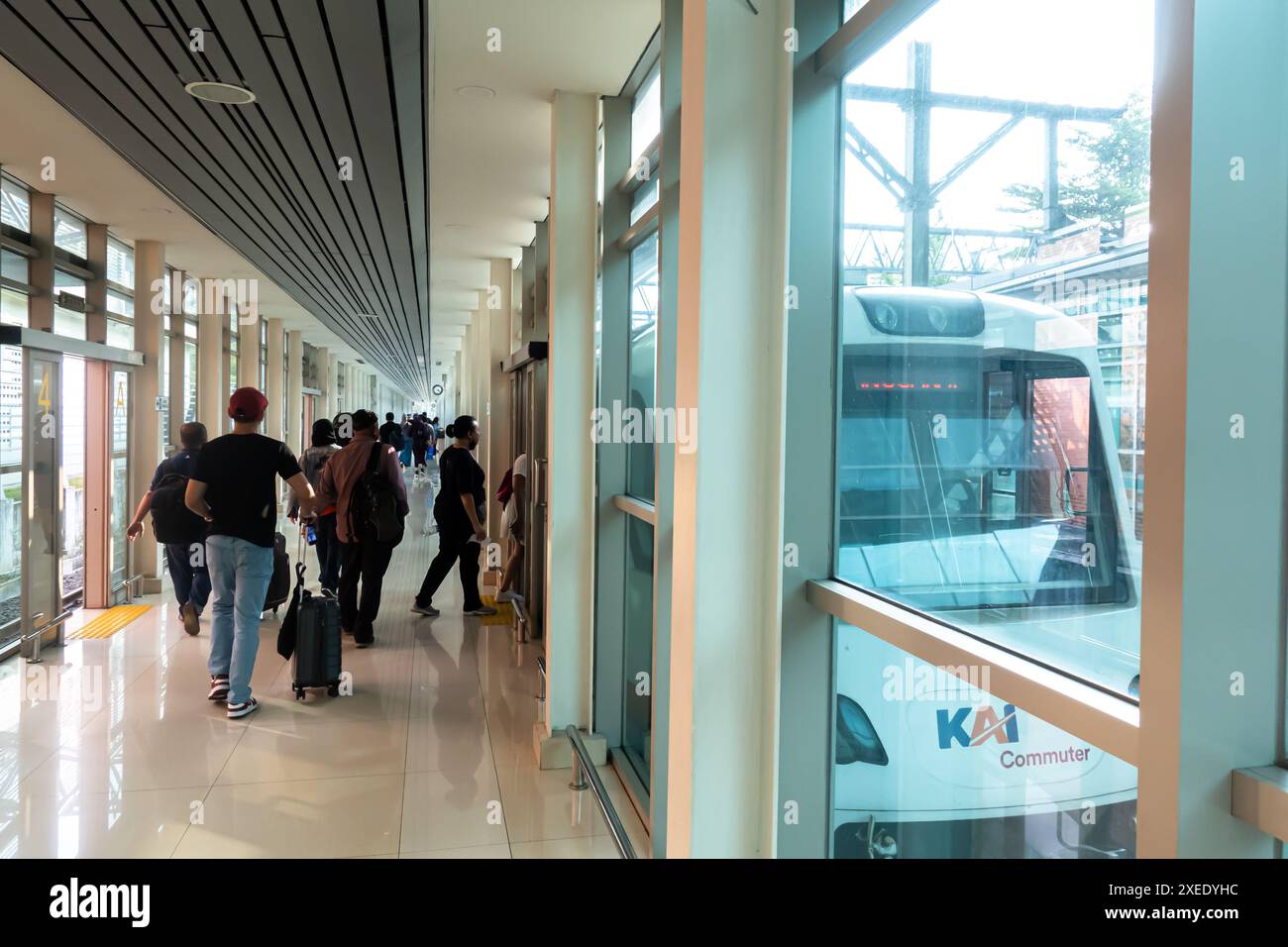 Commuters boarding train at Soekarno station platform with shielded ...