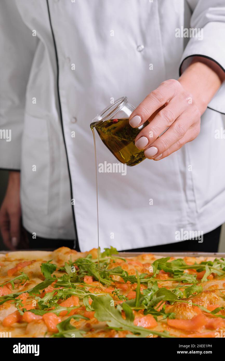 Chef pouring olive oil on pizza Stock Photo - Alamy