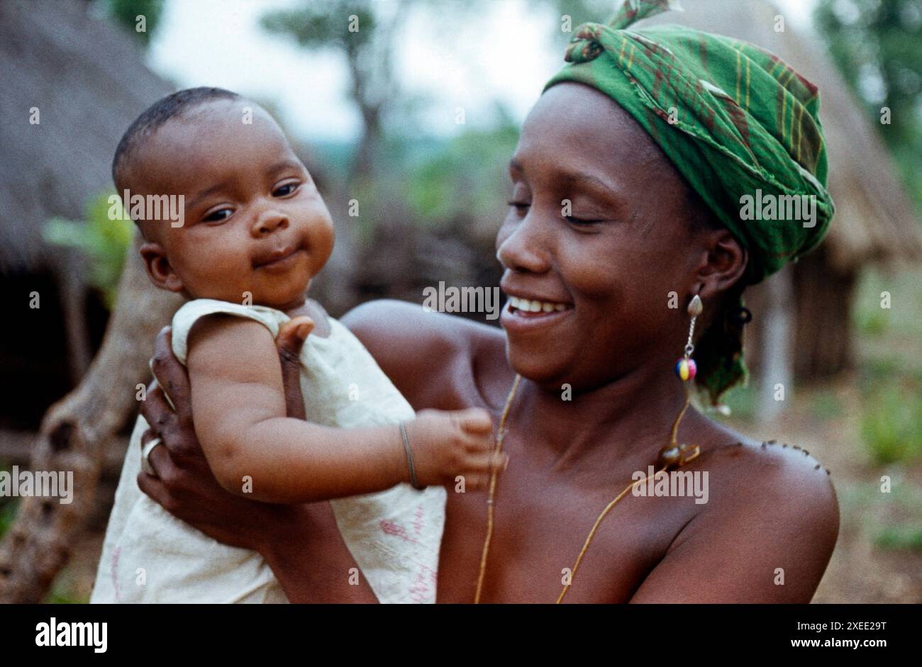 Susu-Frau mit Baby vor ihrer Huette in der Buschsavanne in Sierra Leone ...