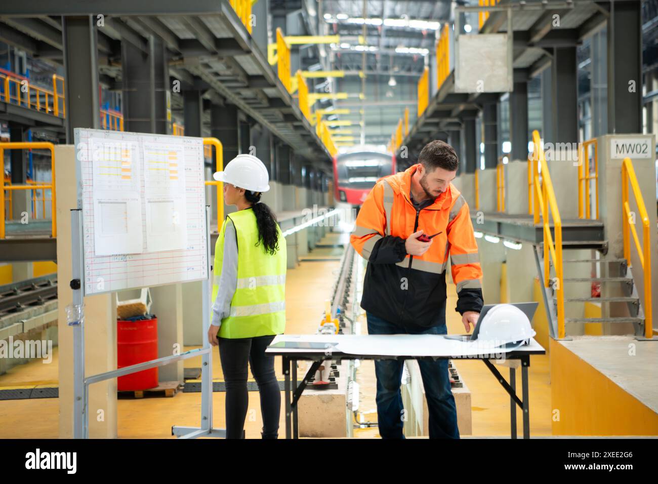 Male and female engineers work together in an electric repair station, Check the details of the ...