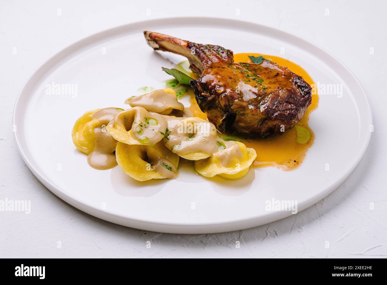 tomahawk steak and ravioli on plate Stock Photo - Alamy