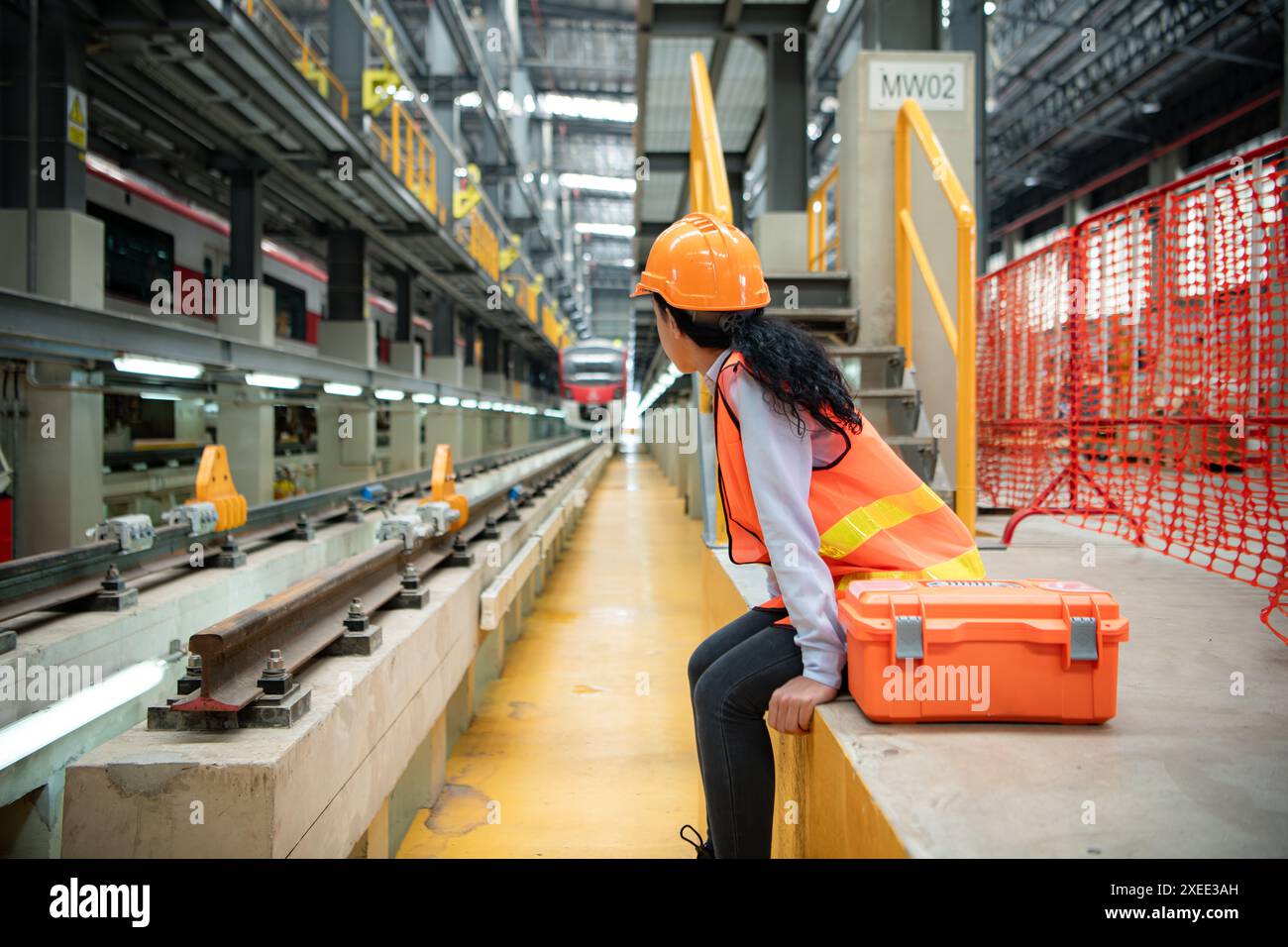 Portrait of female technician with toolbox, Sitting on a cement ...