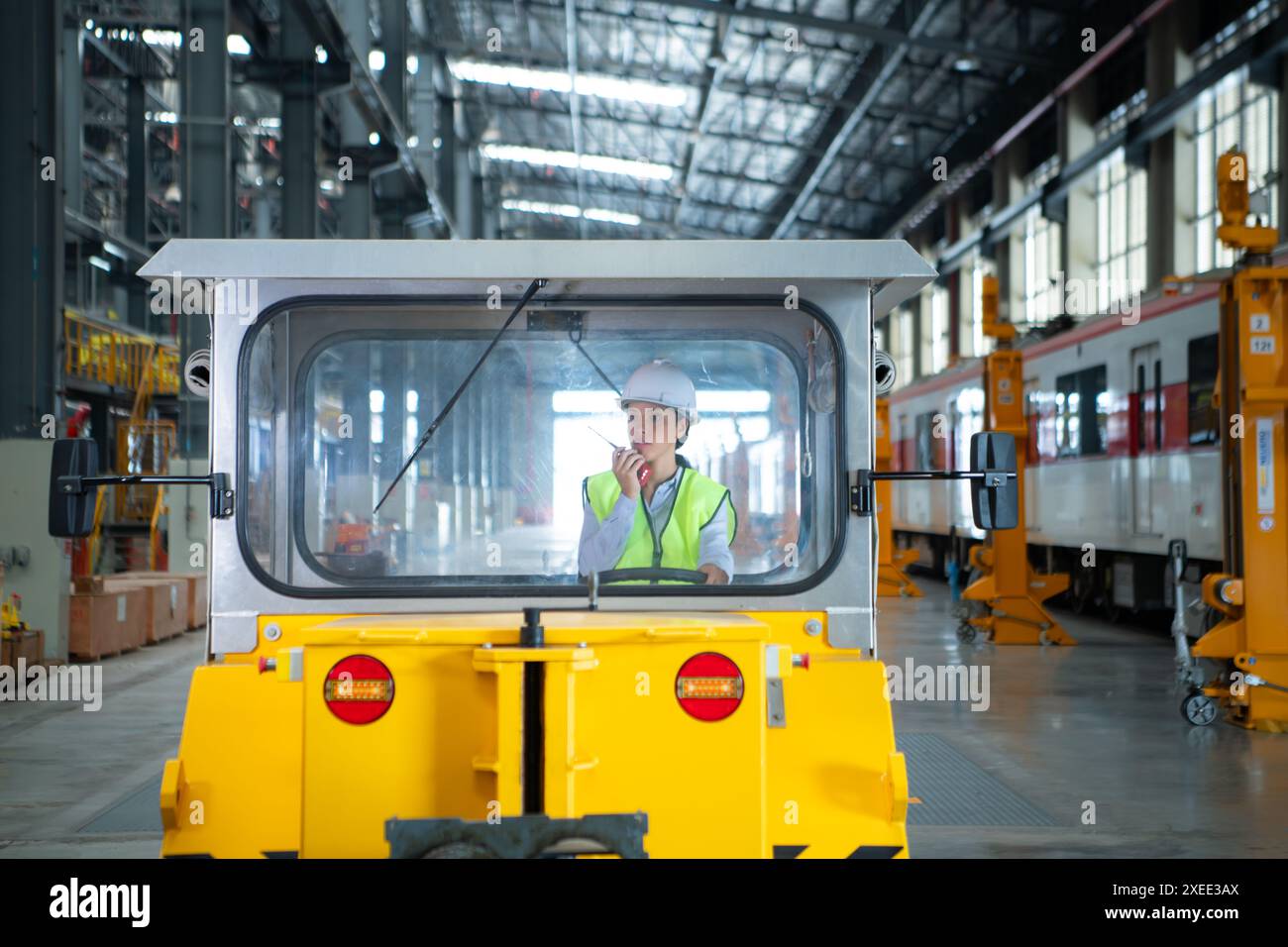 Female engineer working in electric train repair shop, Test driving a ...