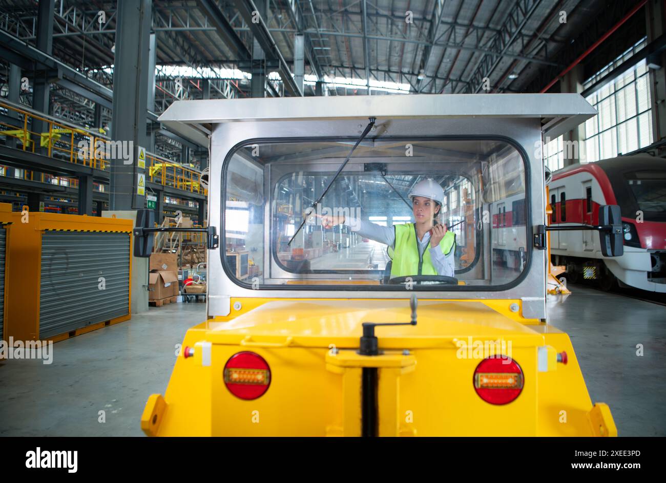 Female engineer working in electric train repair shop, Test driving a ...