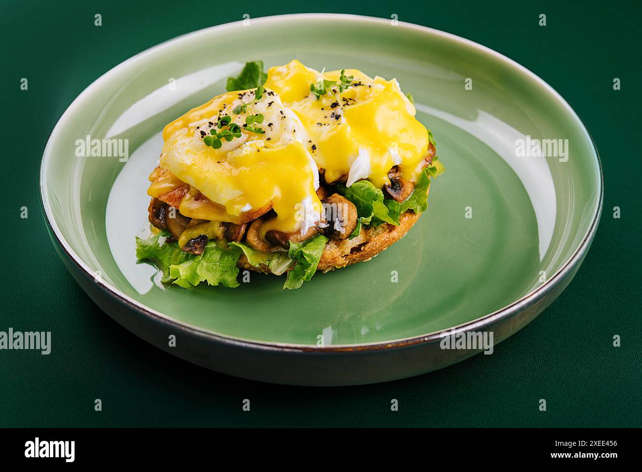 Tasty egg Benedict on green plate Stock Photo - Alamy