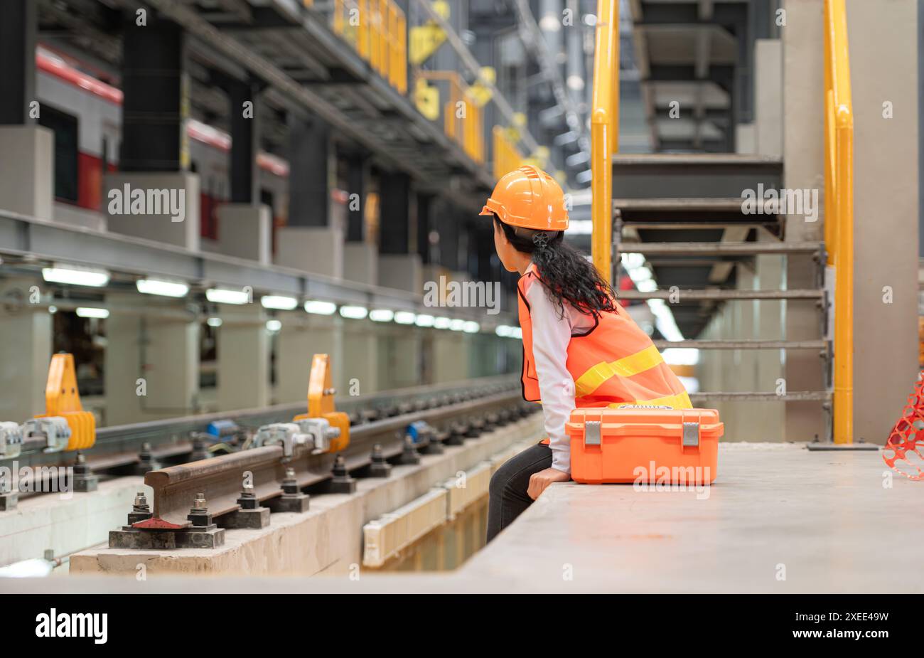 Portrait of female technician with toolbox, Sitting on a cement ...