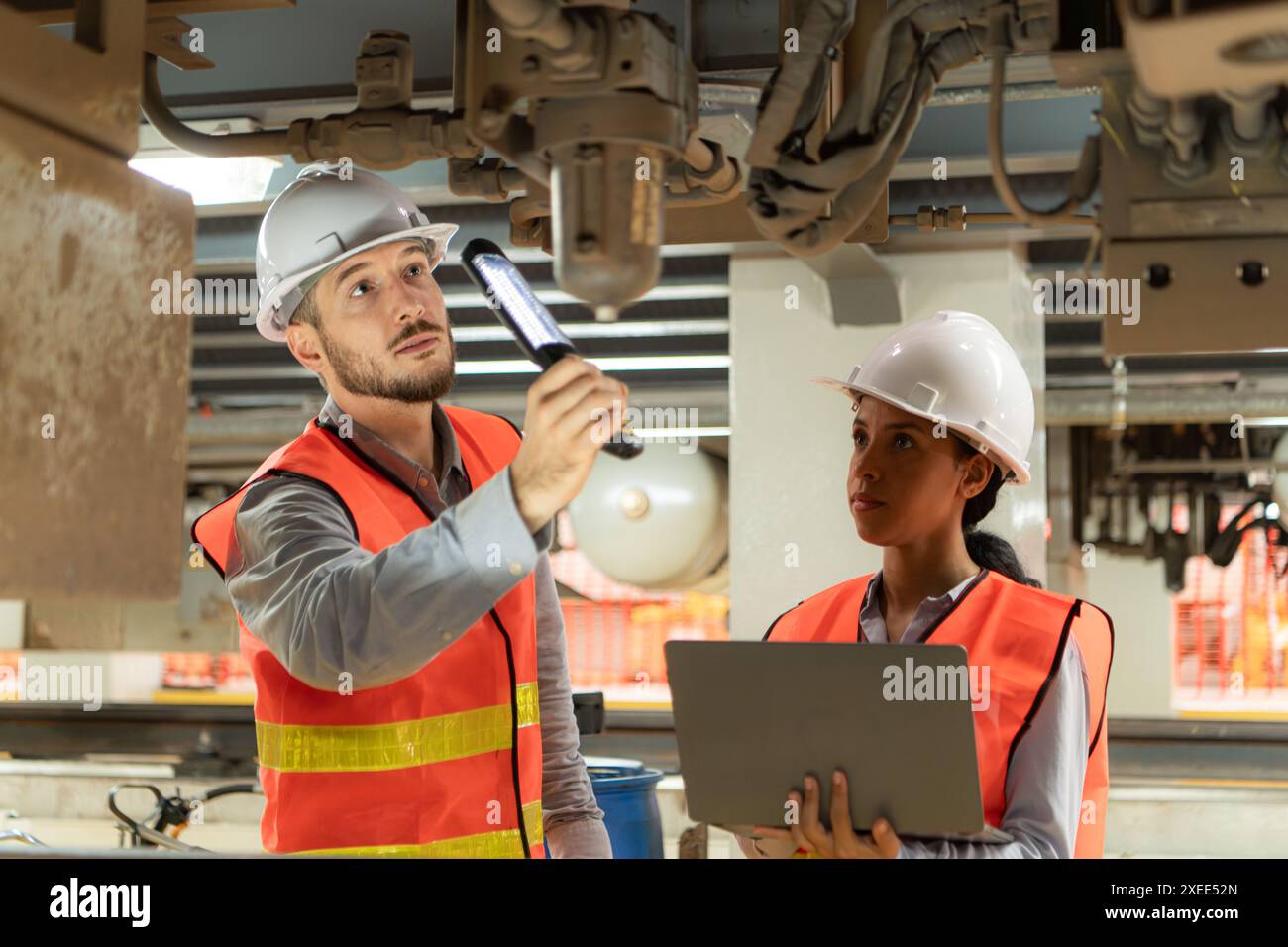 Male and female engineers work together in an electric repair station. Inspecting the ...