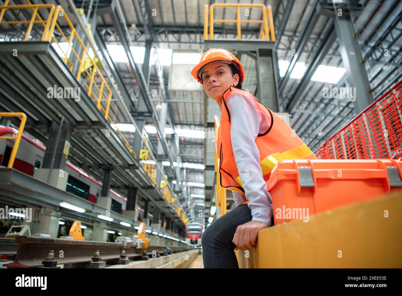 Portrait of female technician with toolbox, Sitting on a cement ...