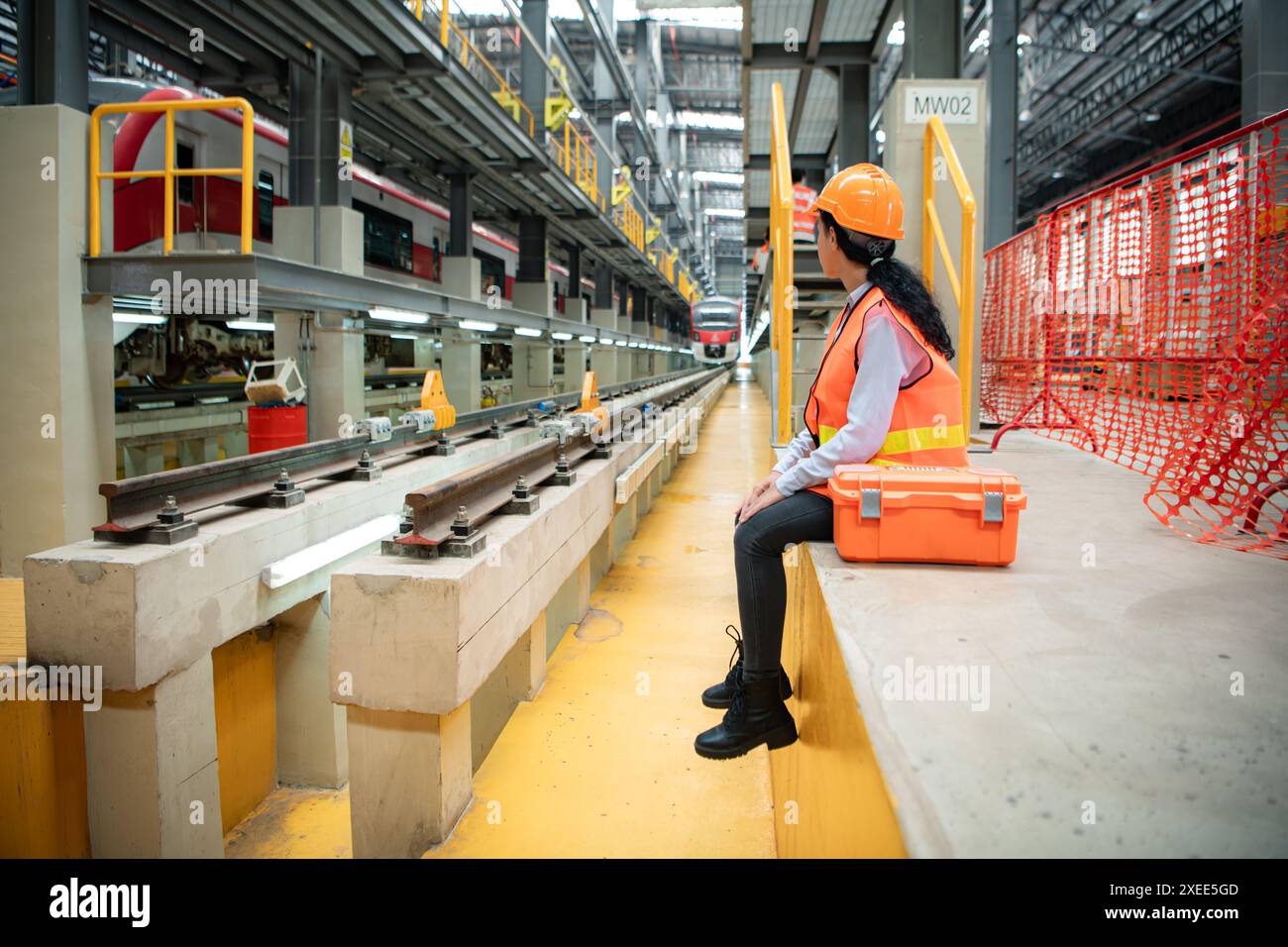 Portrait of female technician with toolbox, Sitting on a cement ...