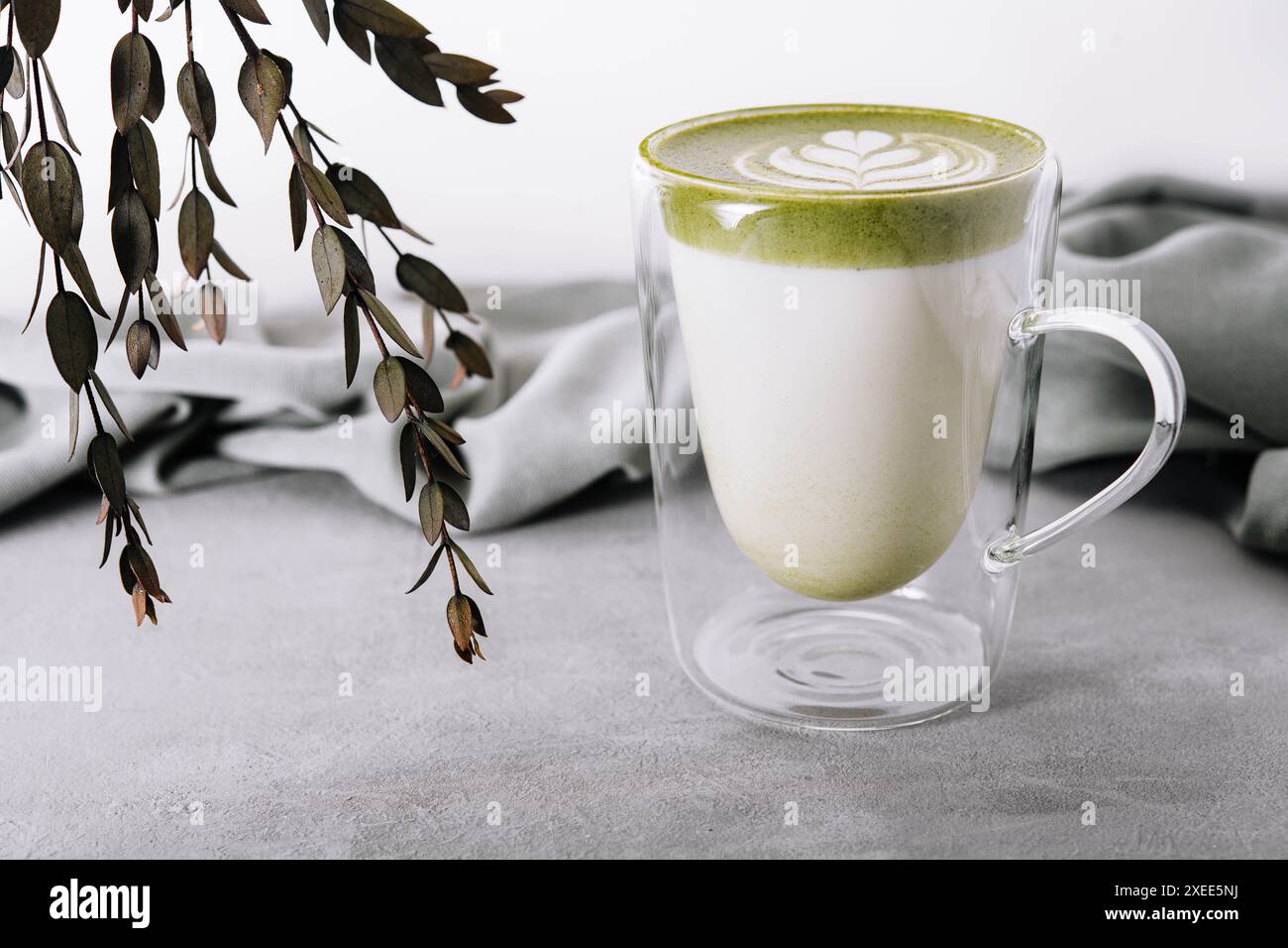 Glass of hot matcha green tea latte with tulip pattern Stock Photo - Alamy