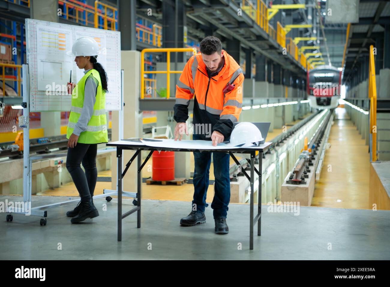 Male and female engineers work together in an electric repair station, Check the details of the ...