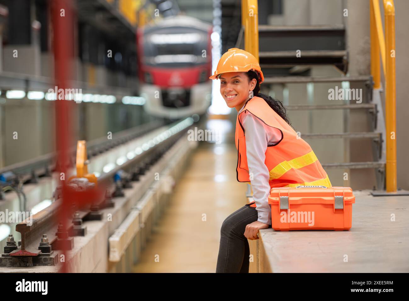 Portrait of female technician with toolbox, Sitting on a cement ...