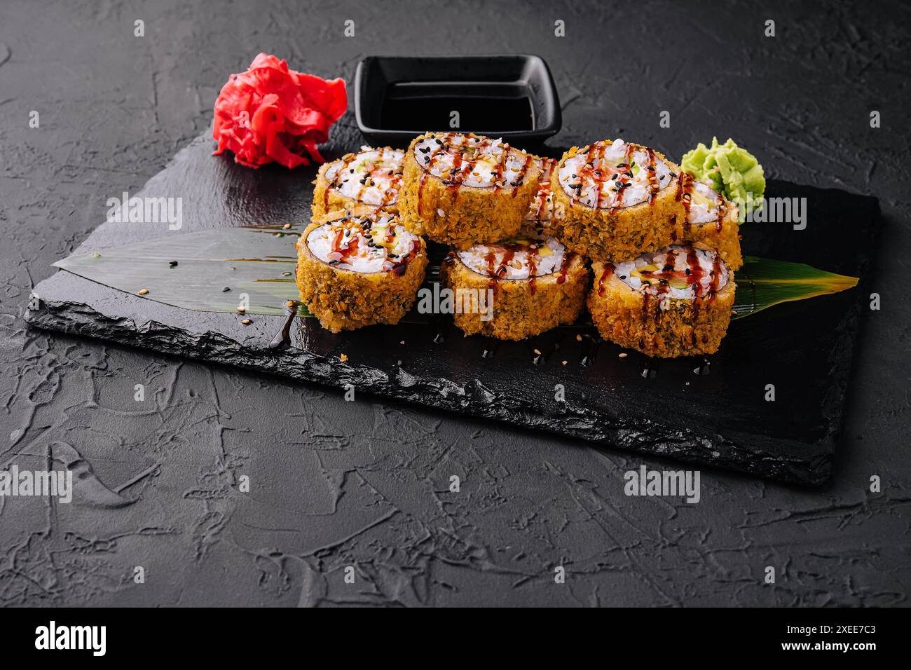 Warm sushi rolls with avocado on black Stock Photo - Alamy