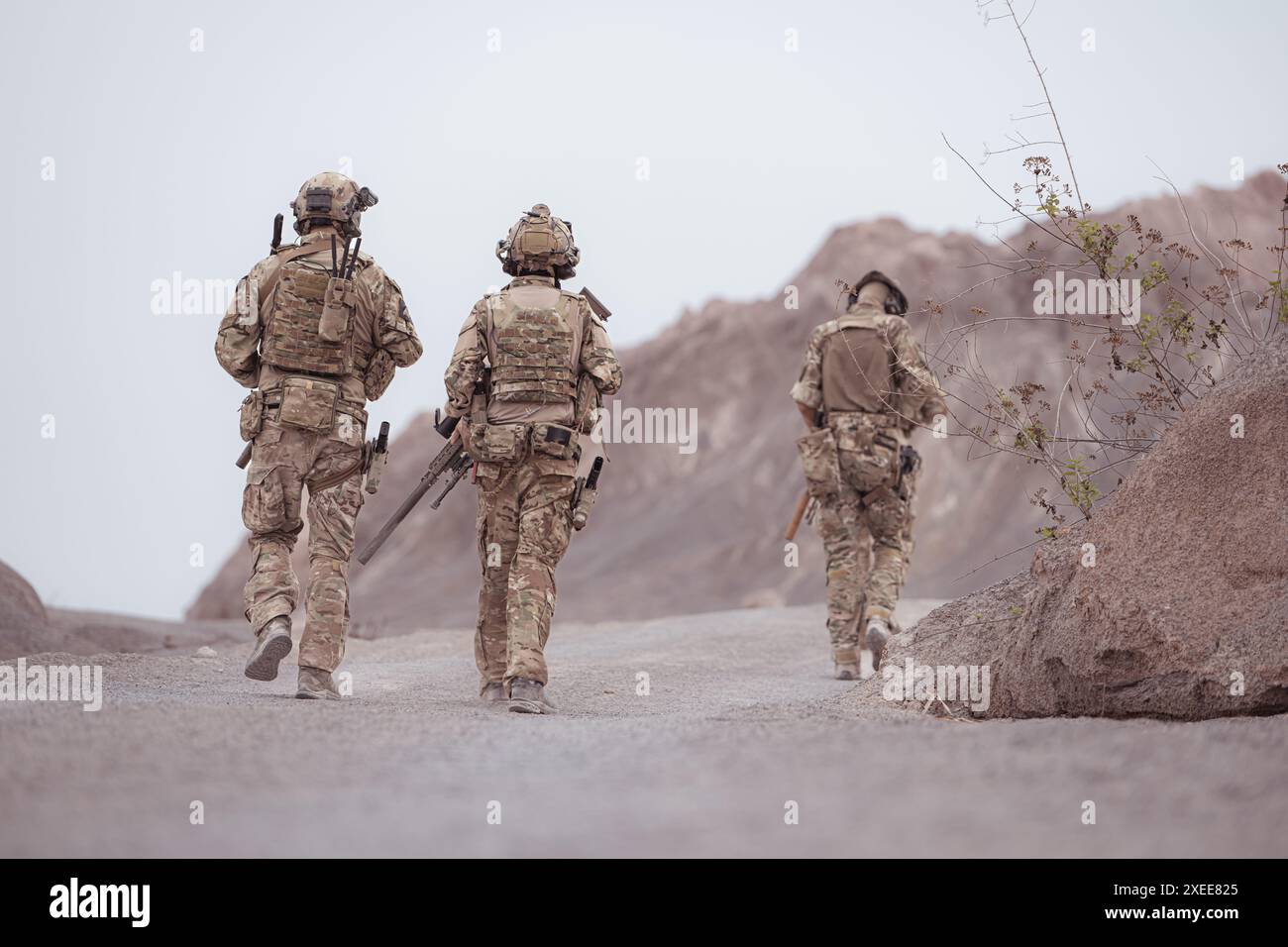 Soldiers in camouflage military uniforms carrying weapons ...