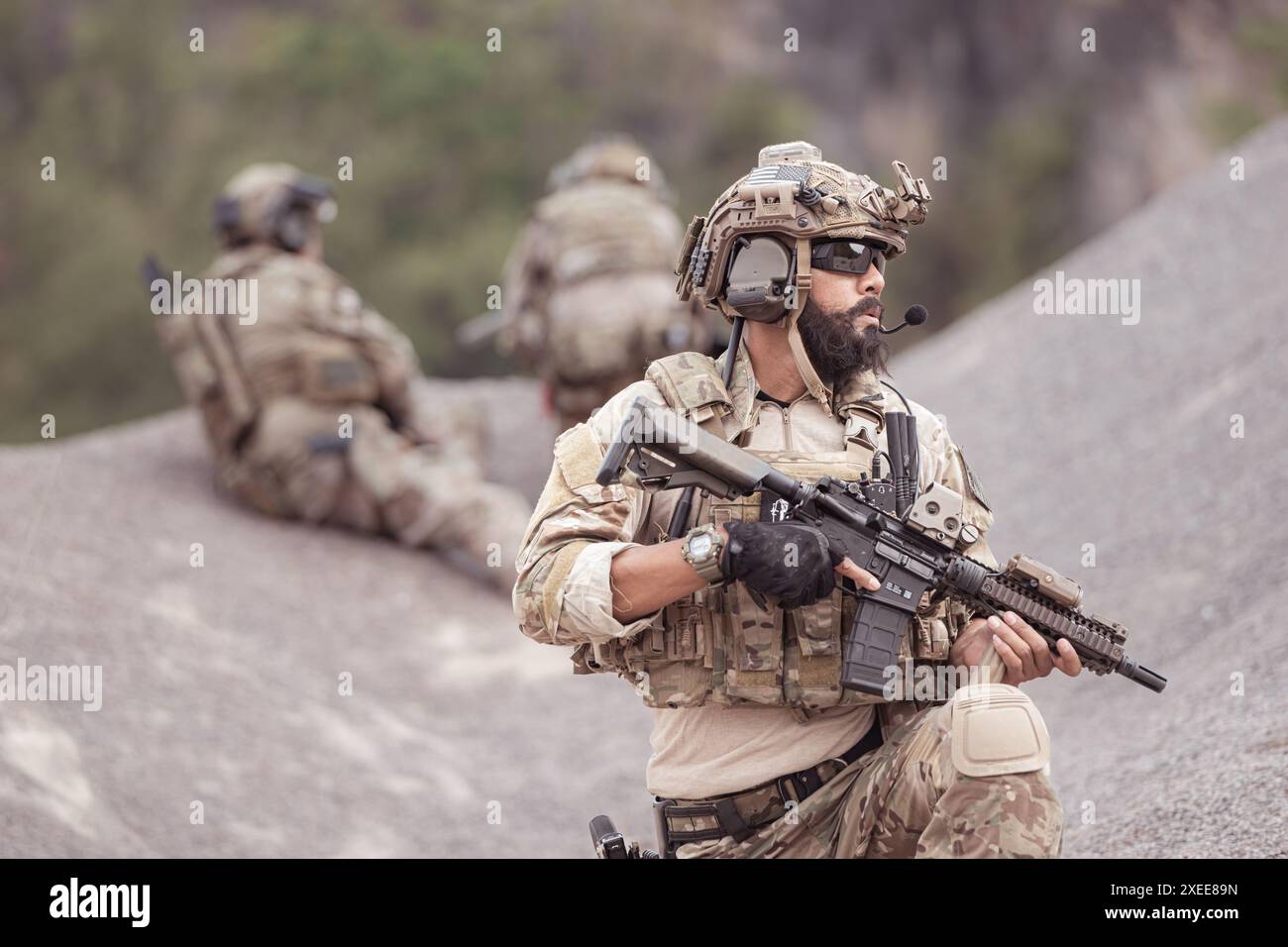 Soldiers in camouflage military uniforms carrying weapons ...