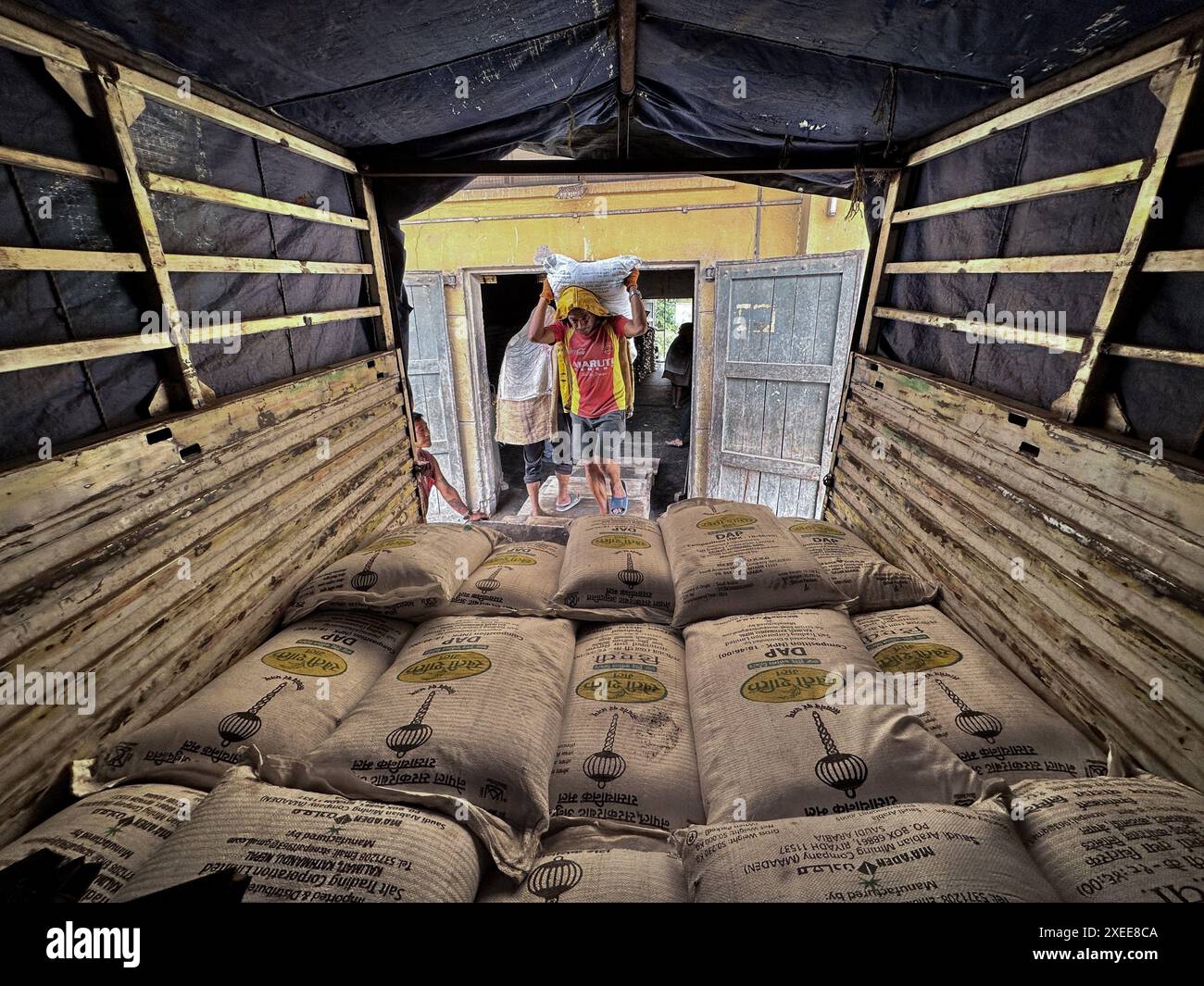 June 27, 2024: A worker carries a sack of chemical fertilizer for ...