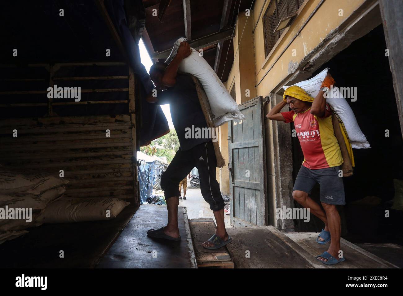 June 27, 2024: Workers carry sacks of chemical fertilizer for ...