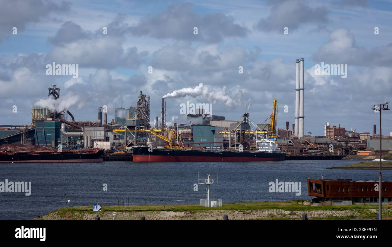 Industrial complex with smoking chimneys in the port of IJmuiden, with ...