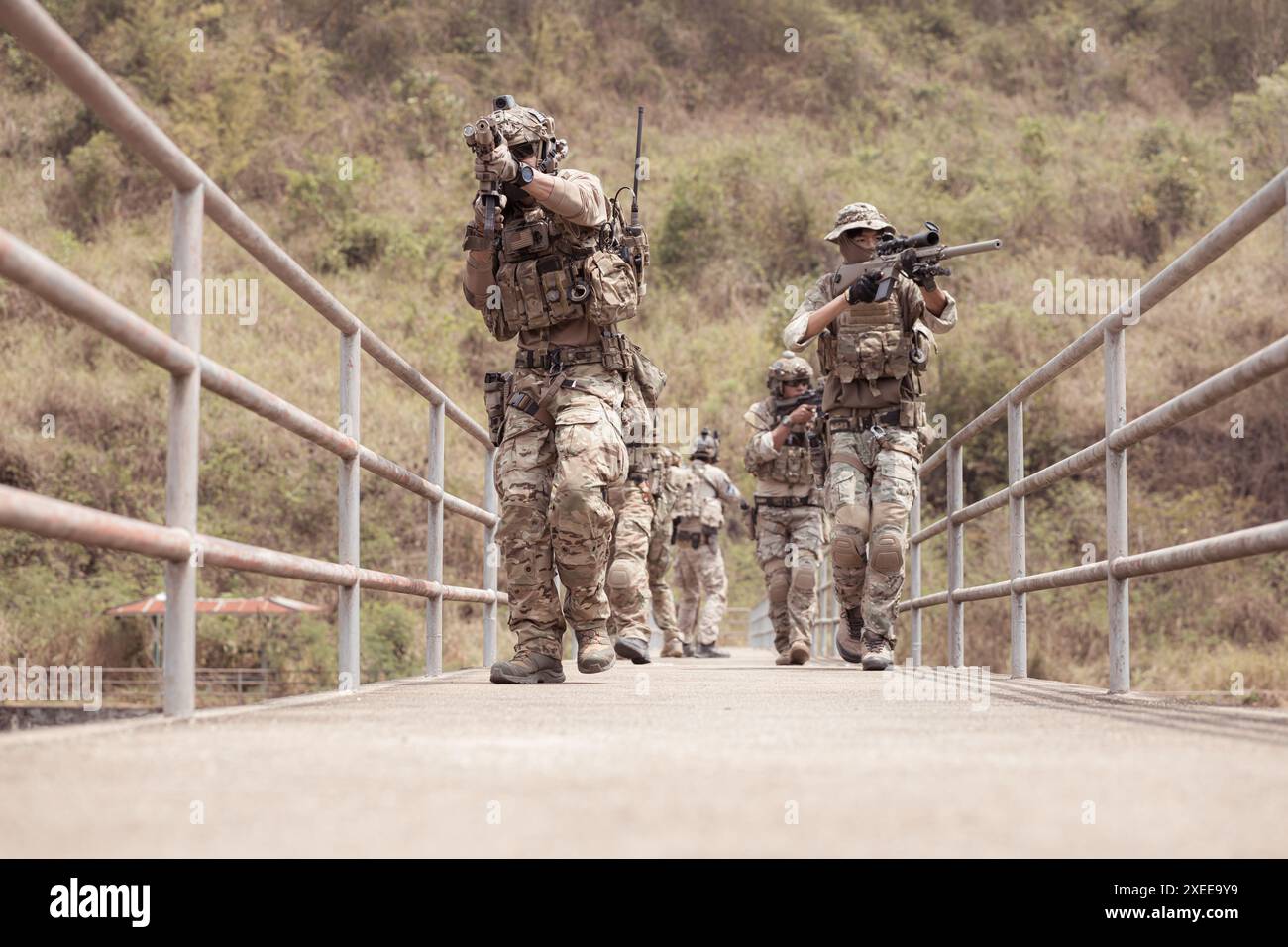 Soldiers in camouflage military uniforms carrying weapons ...