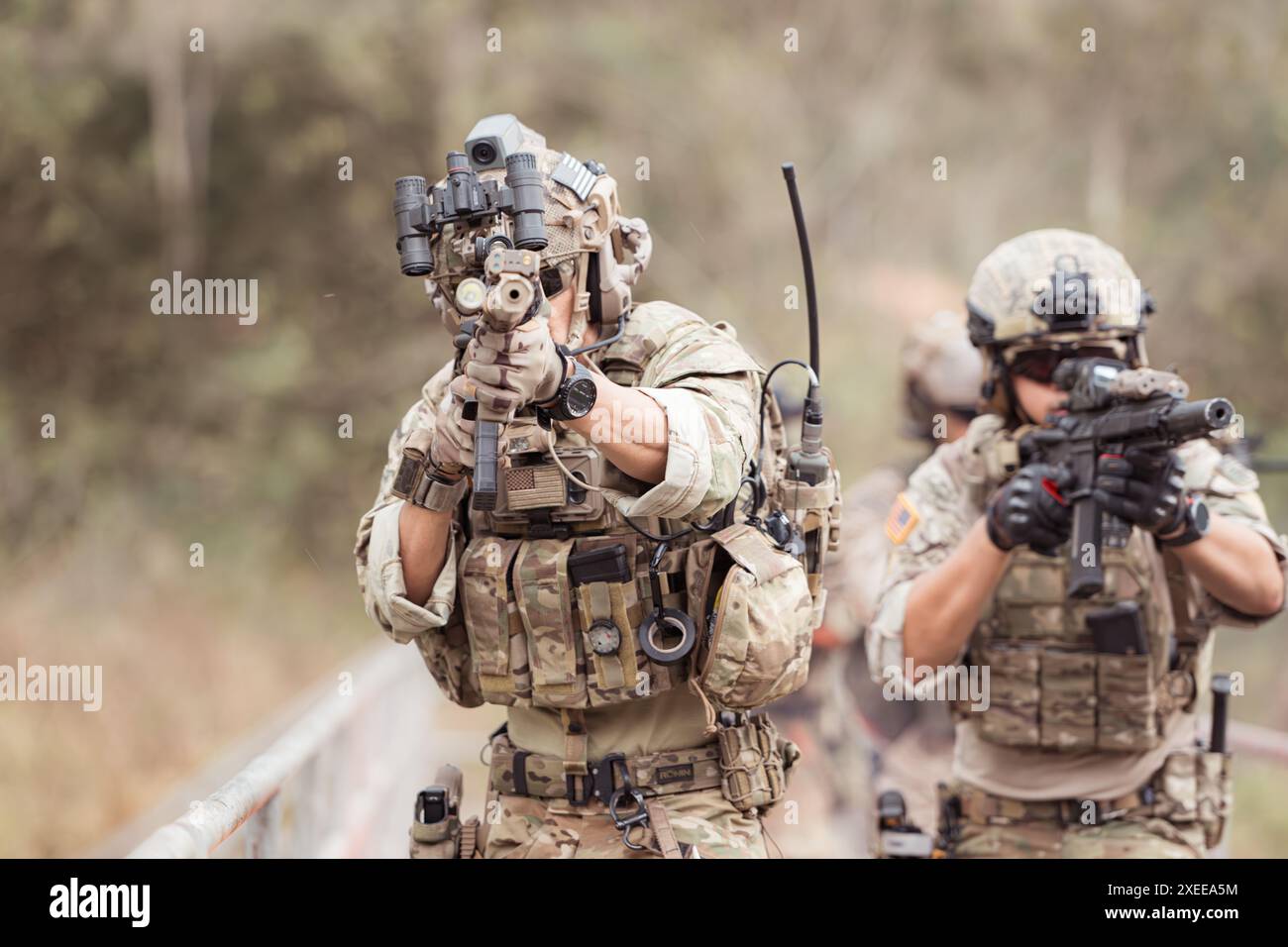 Soldiers in camouflage military uniforms carrying weapons ...