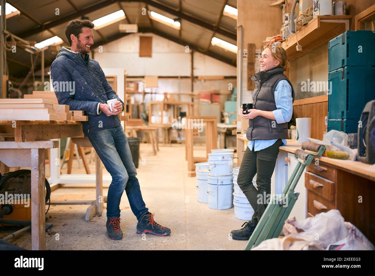 Male And Female Carpenter Working In Woodwork Workshop Talking On ...