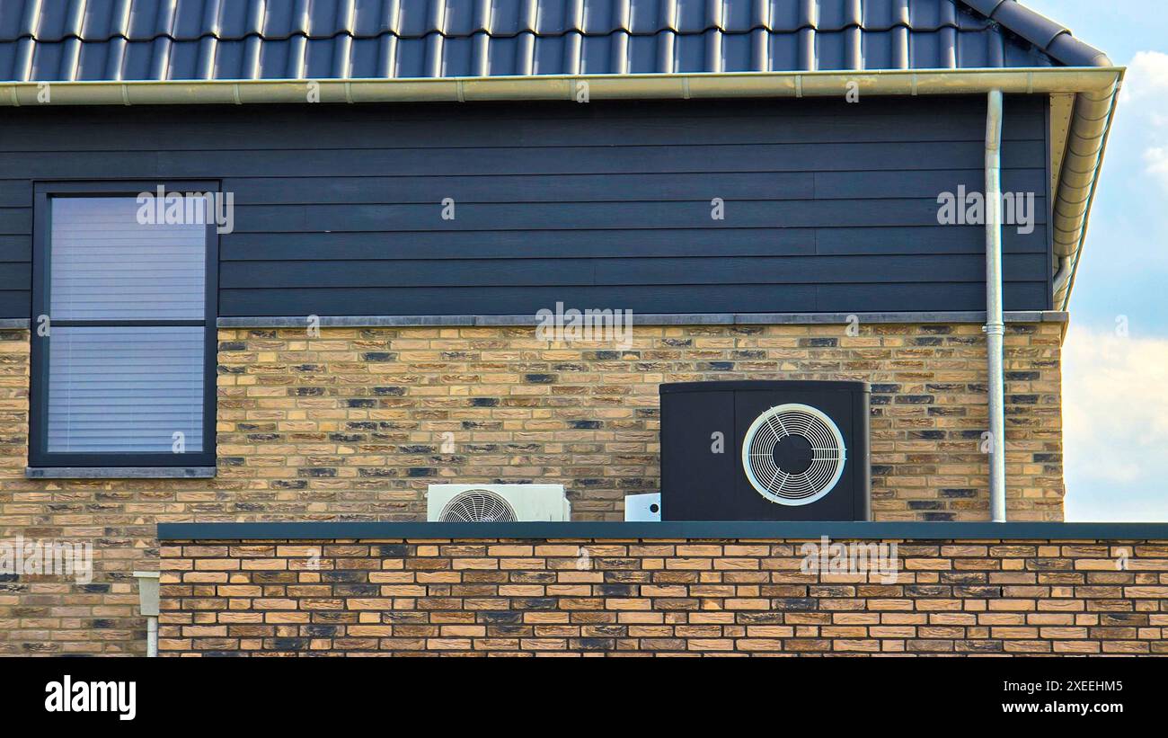 Air source heat pump unit installed outdoors at a modern home with ...